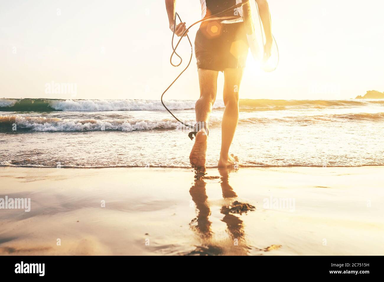 Young man Surfer taking surfboard and comming with long surf board to ...