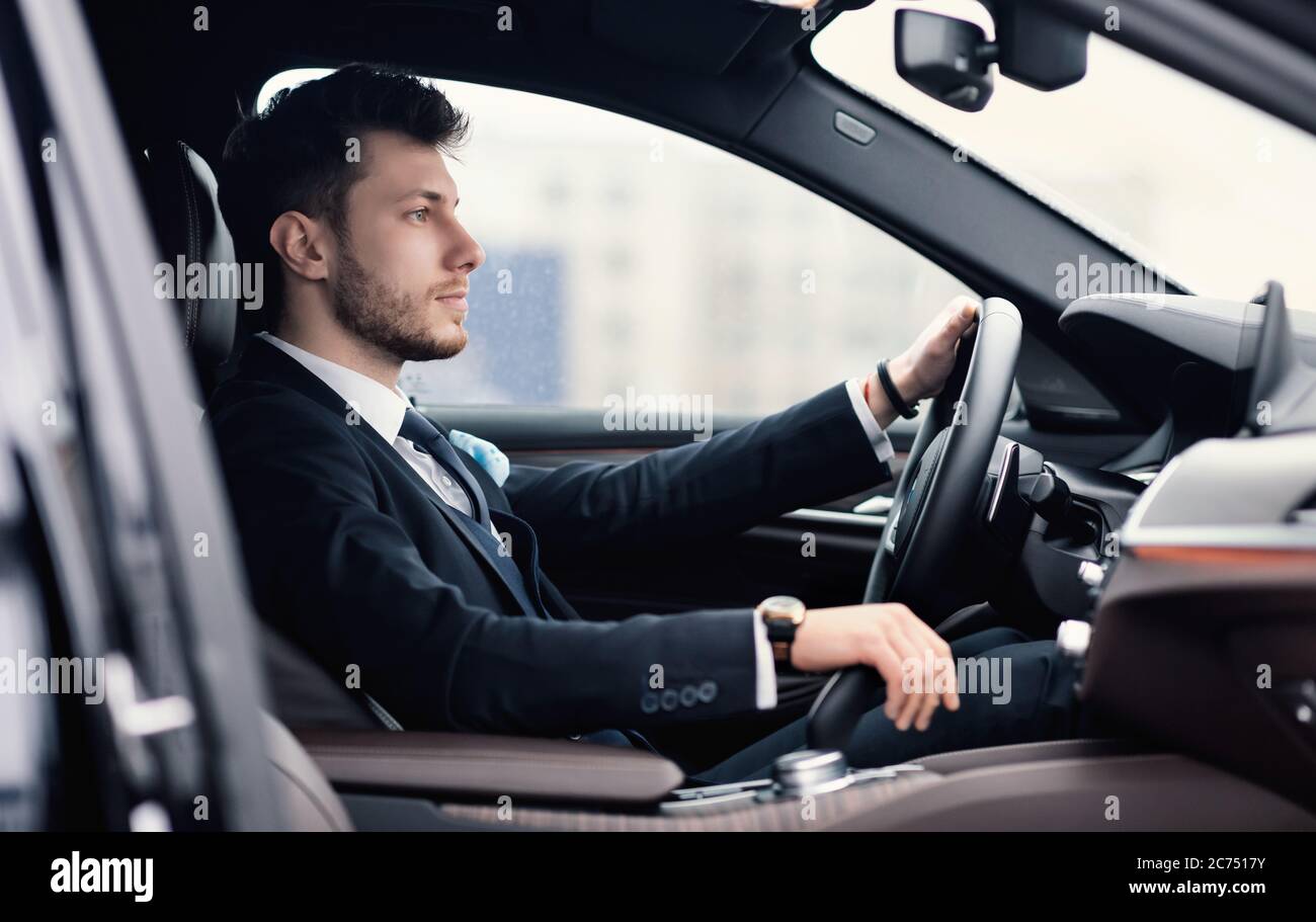 Young business man driving alone in his new car Stock Photo - Alamy