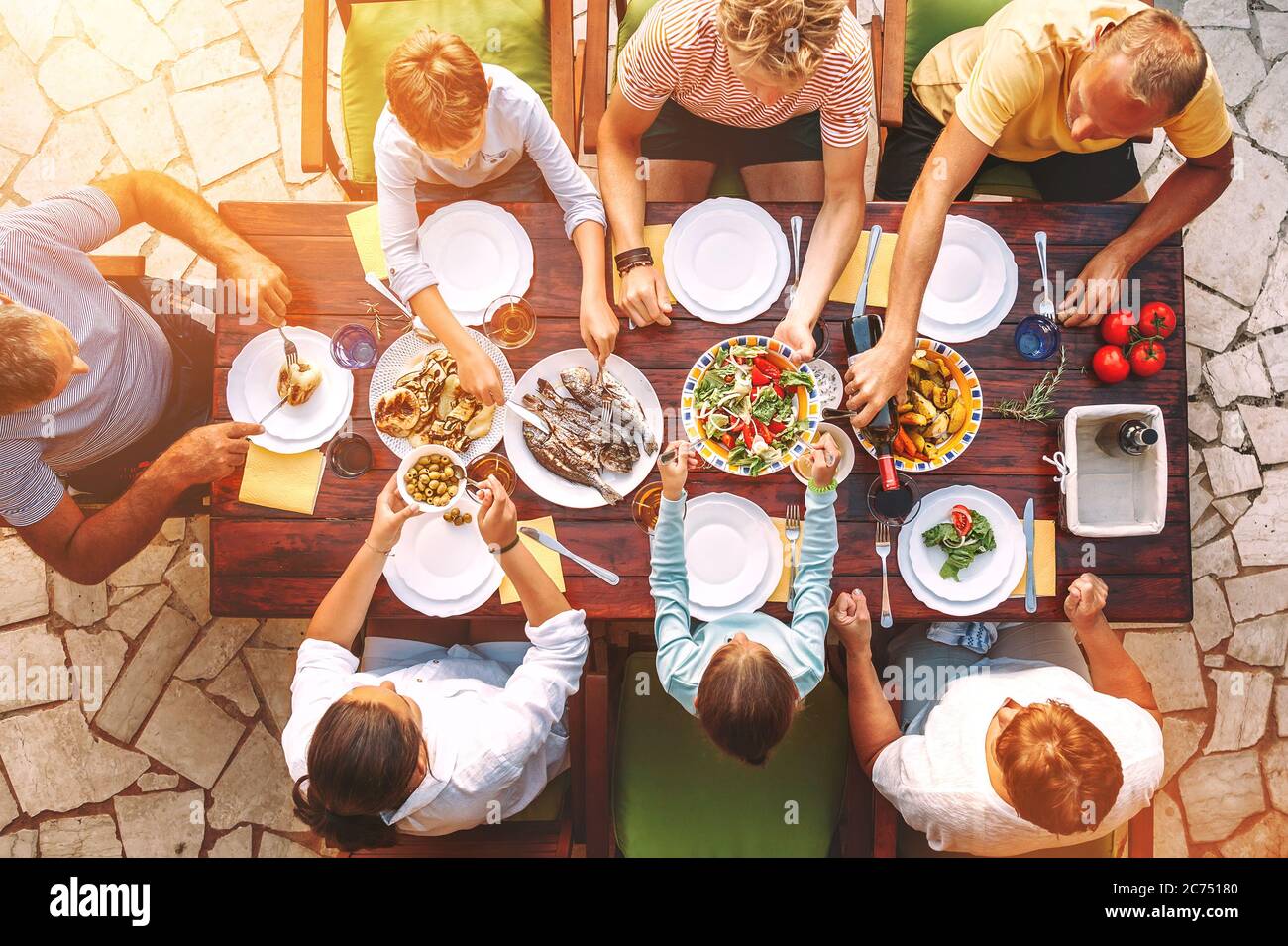 The big family have dinner with a freshly cooked meal on the open ...