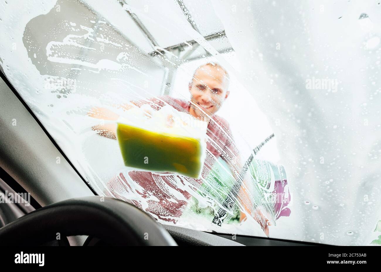Man washing his car windshield window inside the car camera view Stock ...