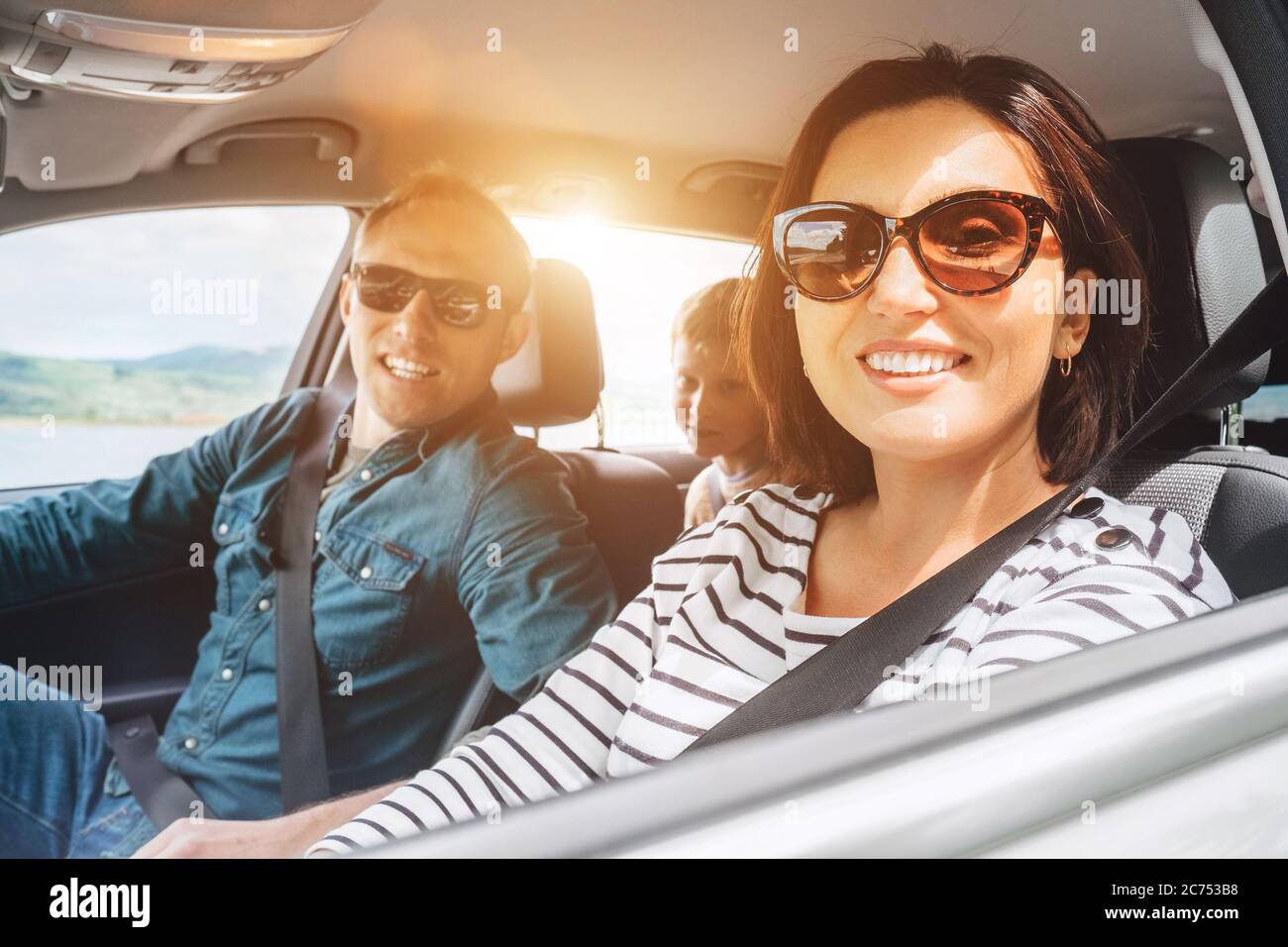 Cheerful young traditional family has a long auto journey and smiling ...