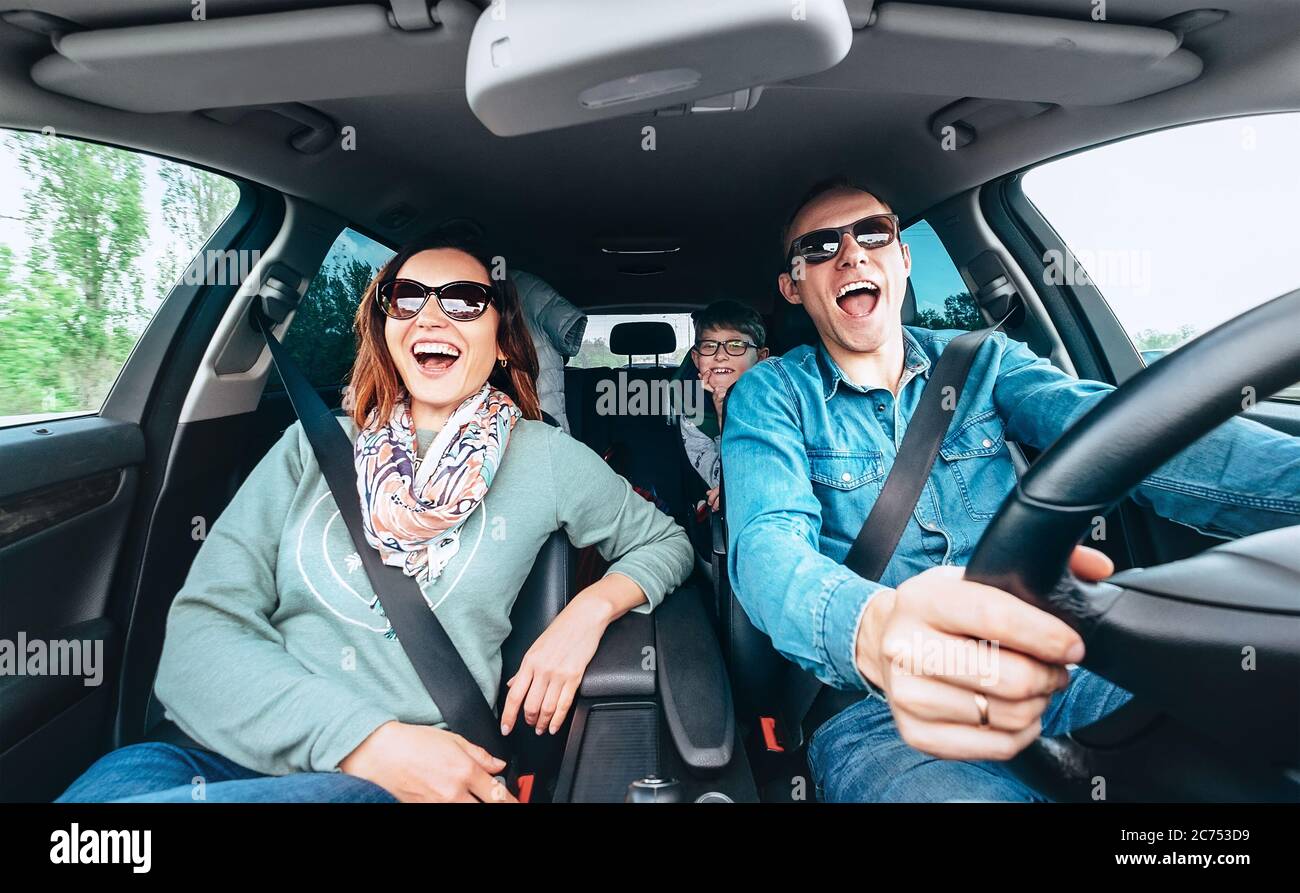 Cheerful young traditional family has a long auto journey and singing ...