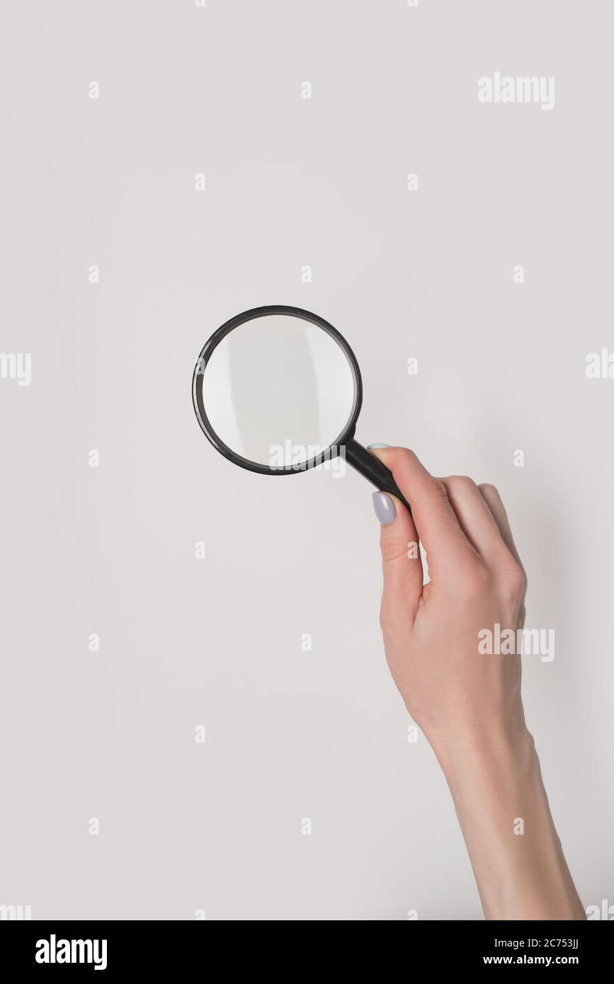 Female hand holding magnifier isolate on light background Stock Photo ...