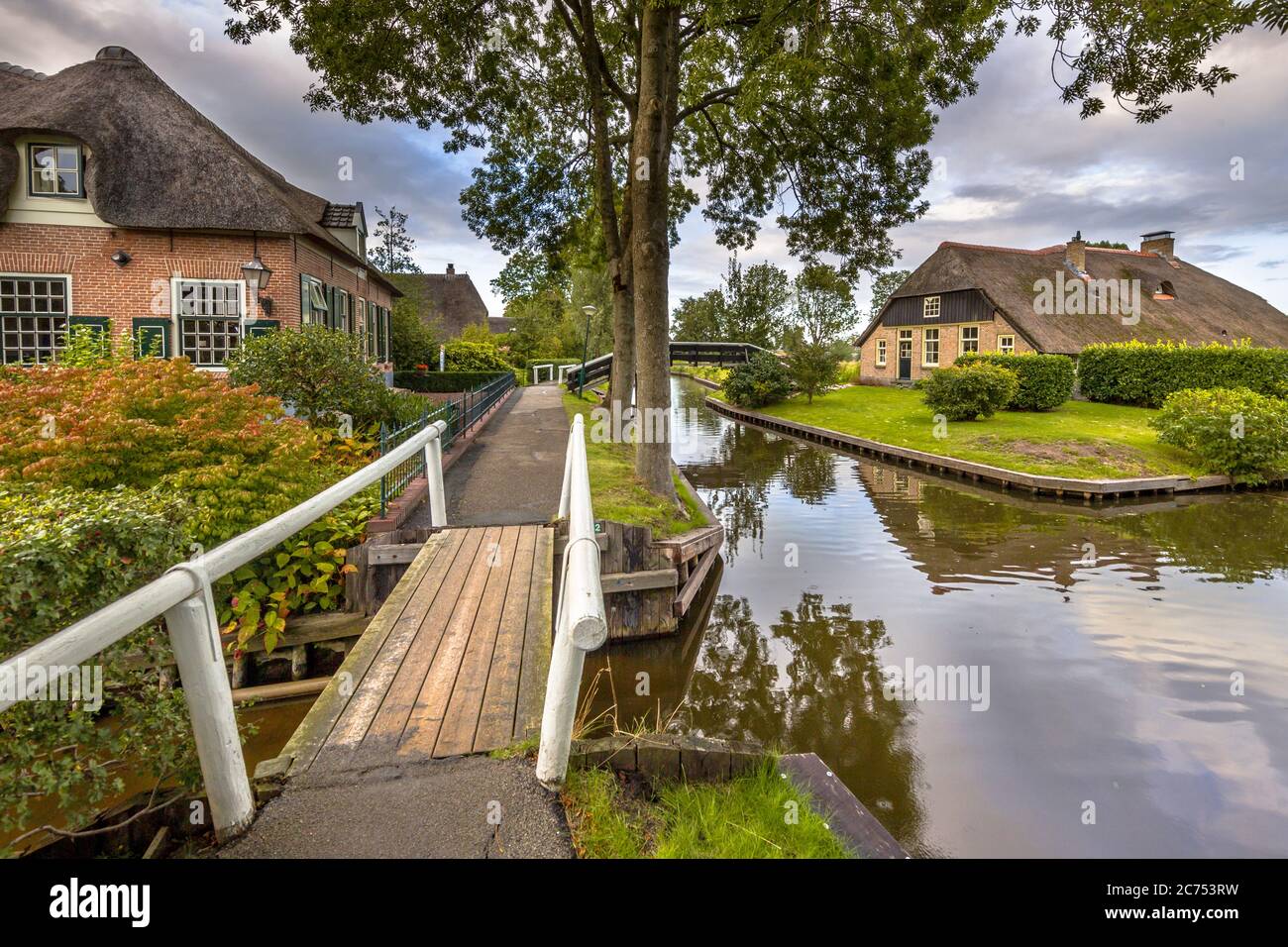 Landscape view of famous Giethoorn village with canals and rustic thatched roof houses in farm ...