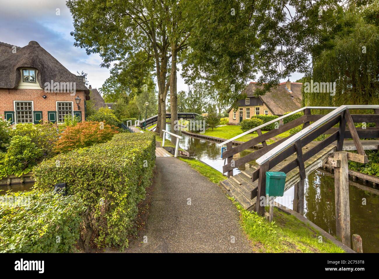 Landscape view of famous Giethoorn village with canals and rustic thatched roof houses in farm ...