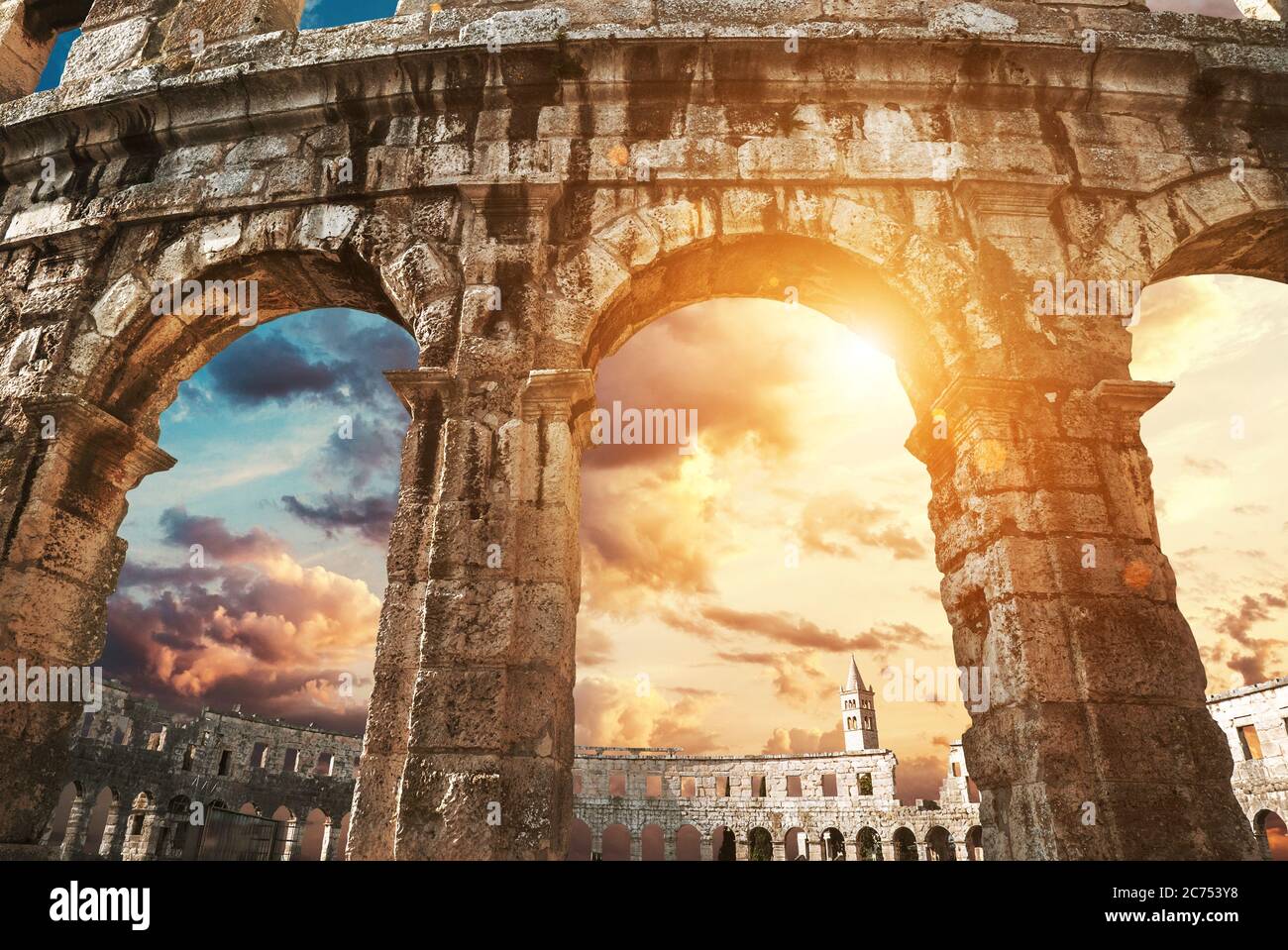 View on church bell tower through amphitheater arches Stock Photo - Alamy