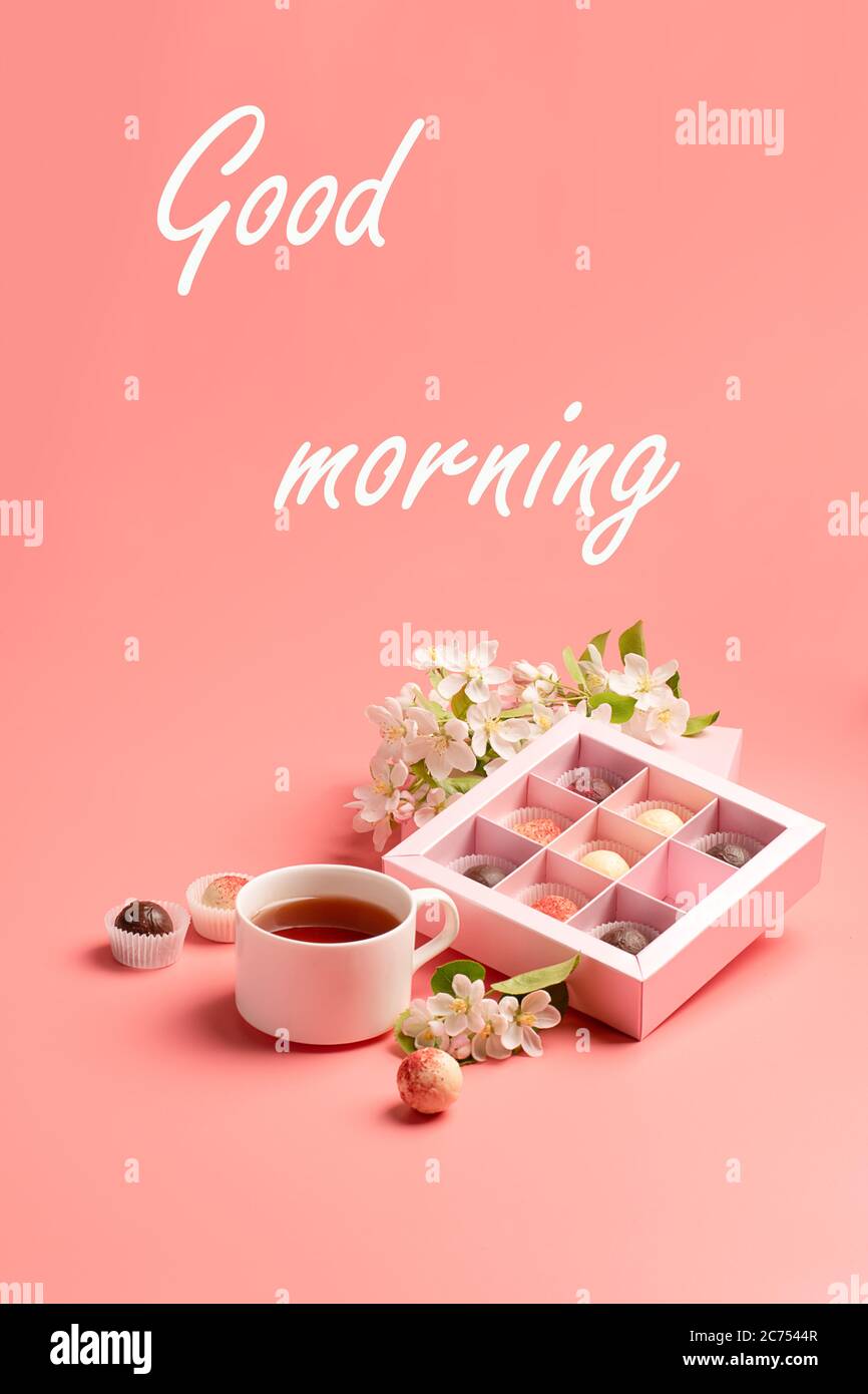 Chocolate candies in an elegant box cup of tea on a pastel pink ...