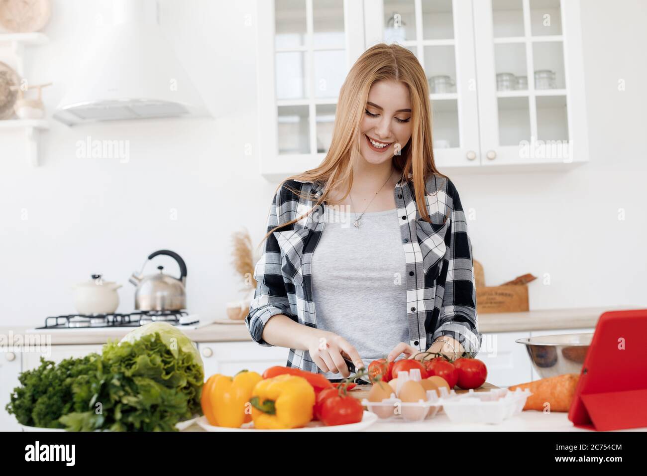 Young woman cooking at home at kitchen with tablet Stock Photo - Alamy