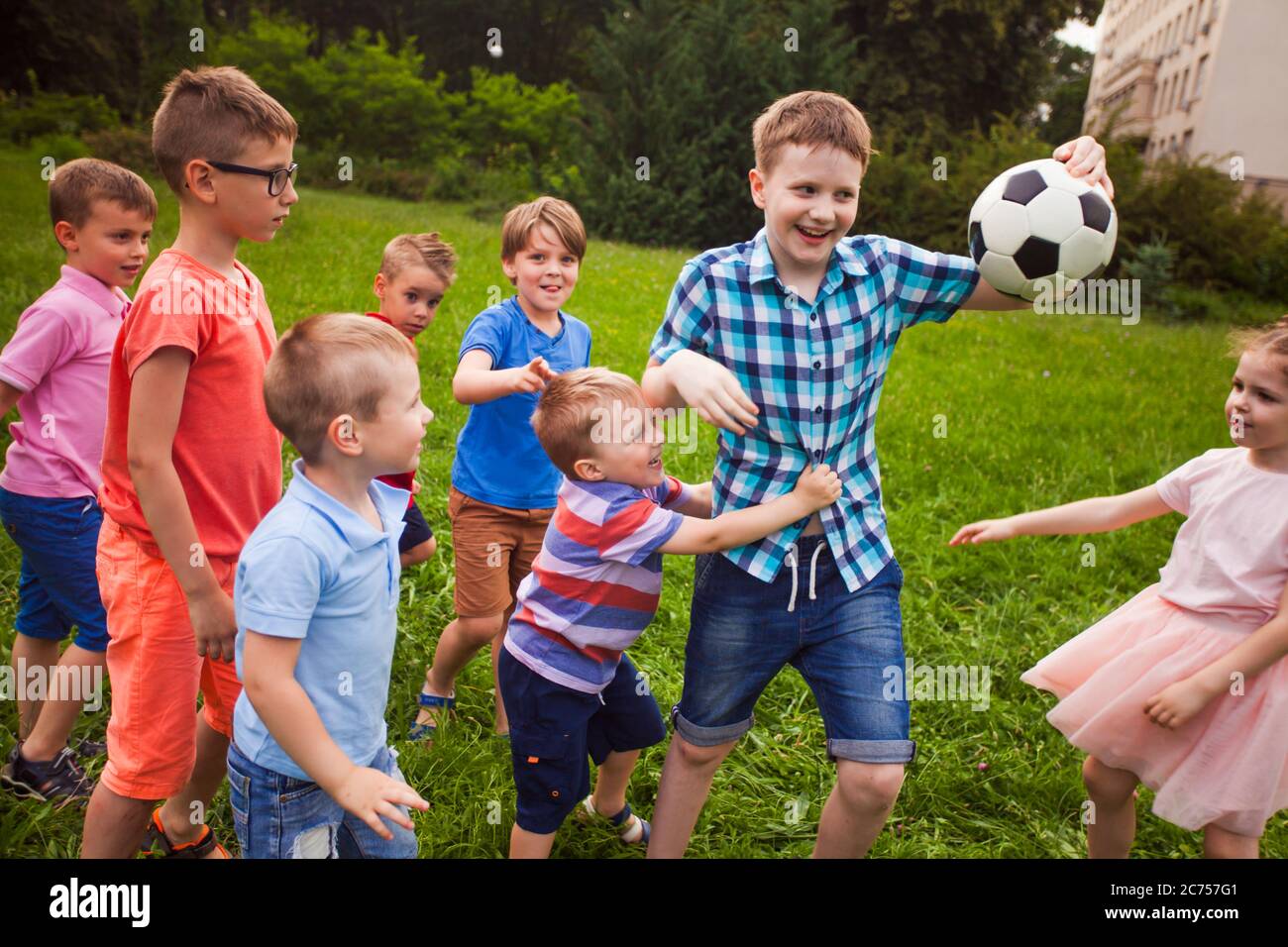The big boy does not want to share the ball with small children Stock ...