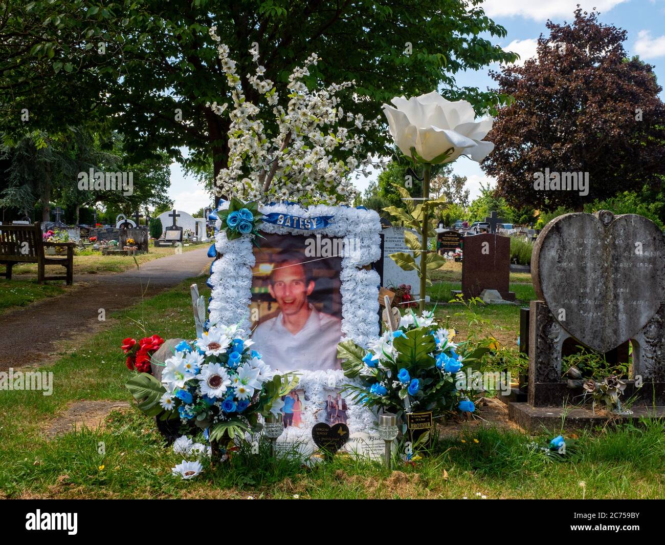 A gravestone with tributes at Cheshunt cemetery, England Stock Photo ...