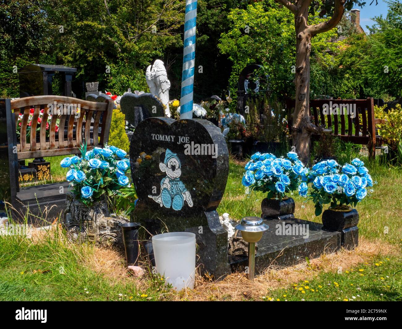 A gravestone with tributes at Cheshunt cemetery, England Stock Photo ...