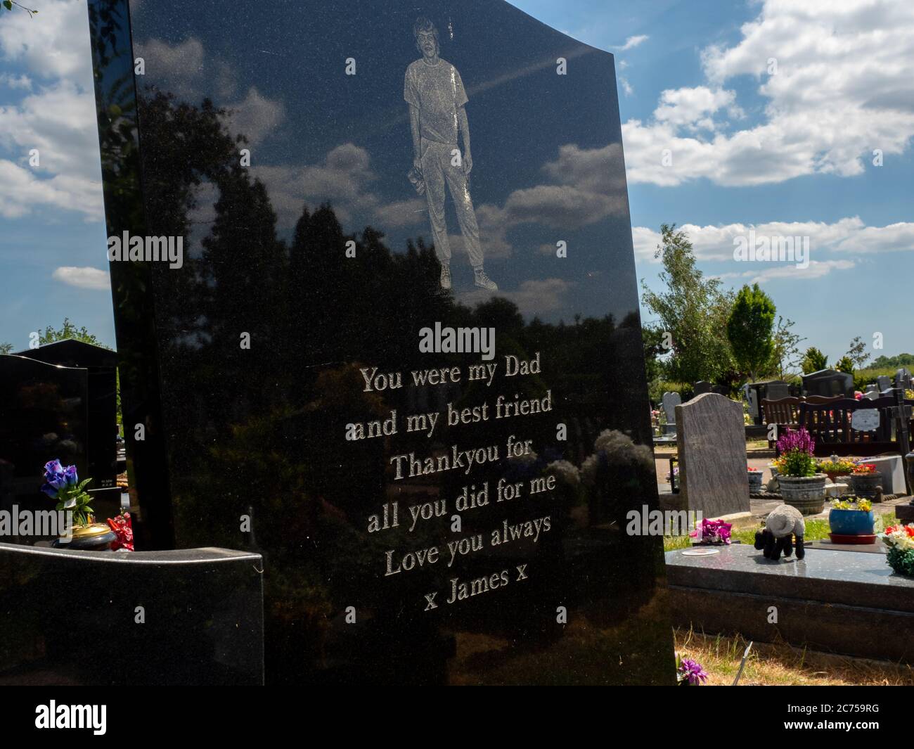 A gravestone with tributes at Cheshunt cemetery, England Stock Photo ...