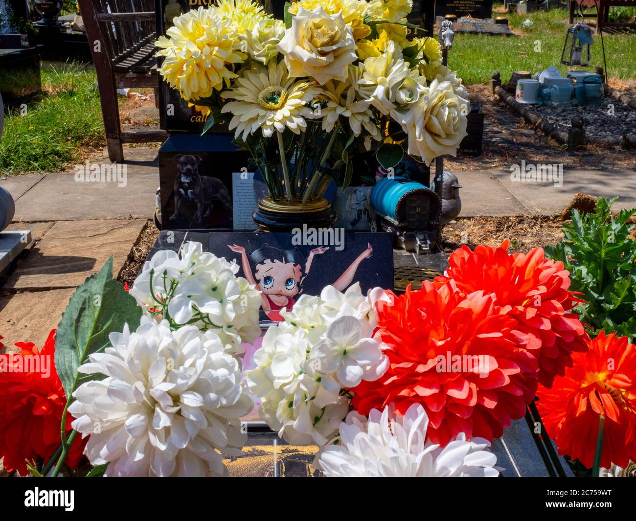 A gravestone with tributes at Cheshunt cemetery, England Stock Photo ...