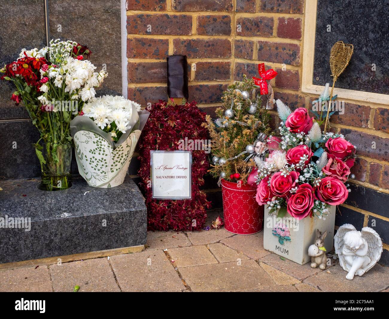 A gravestone with tributes at Cheshunt cemetery, England Stock Photo ...