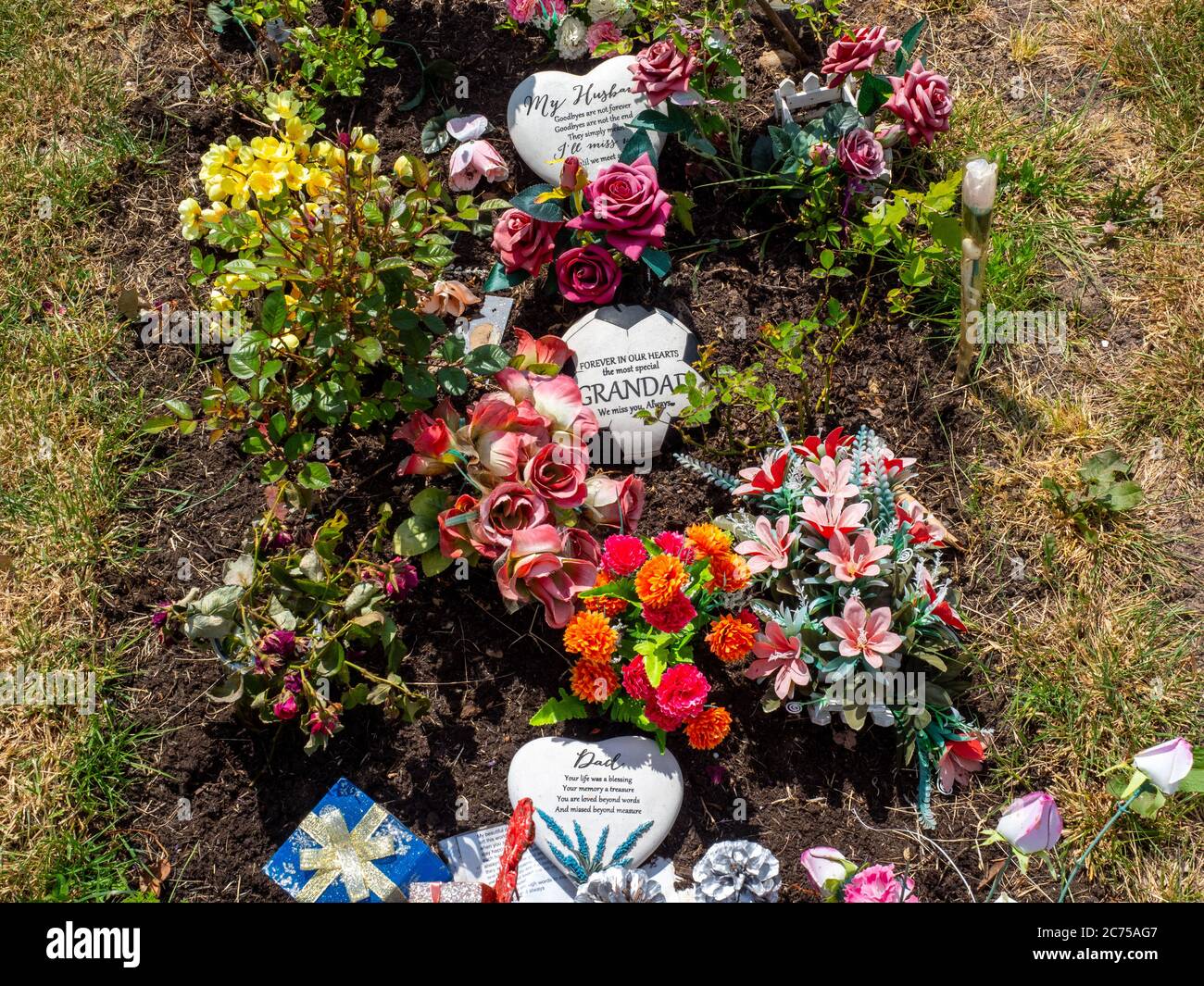 A gravestone with tributes at Cheshunt cemetery, England Stock Photo ...