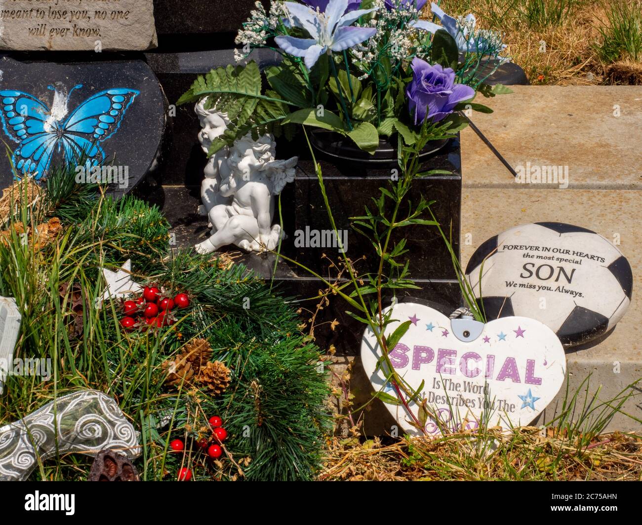 A gravestone with tributes at Cheshunt cemetery, England Stock Photo ...