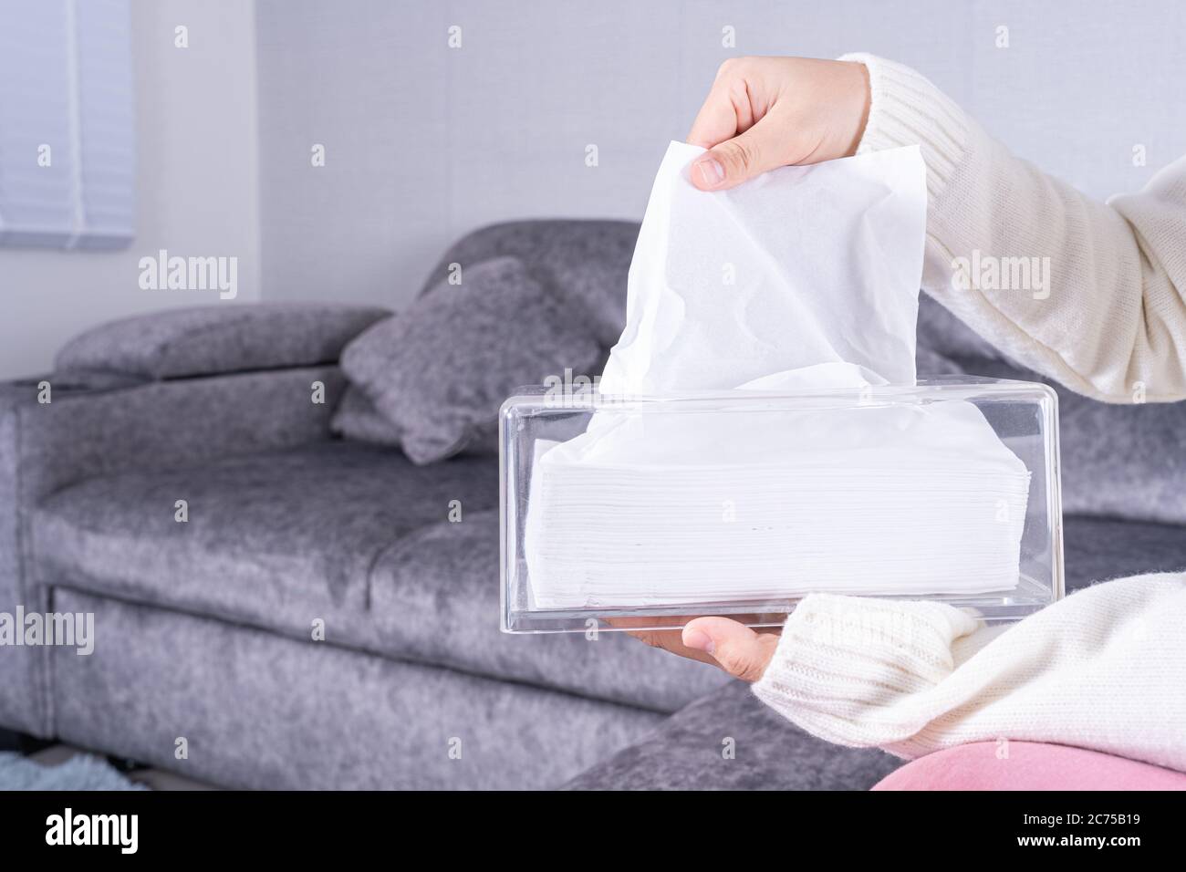 Delicate female hands pulling a white tissue paper out of a transparent ...