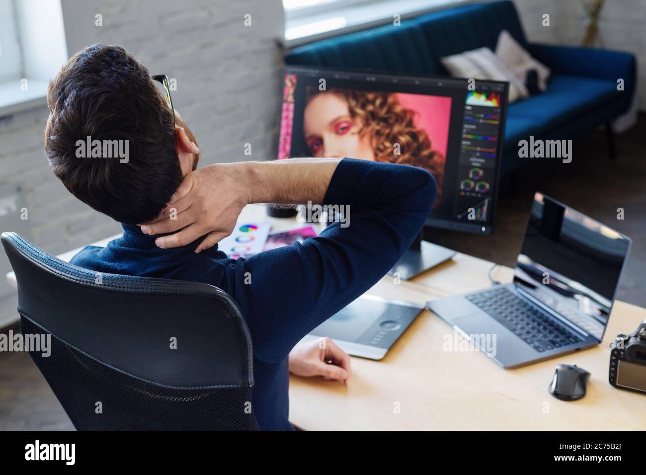 Portrait of tired graphic designer working overtime in office. Stressed ...