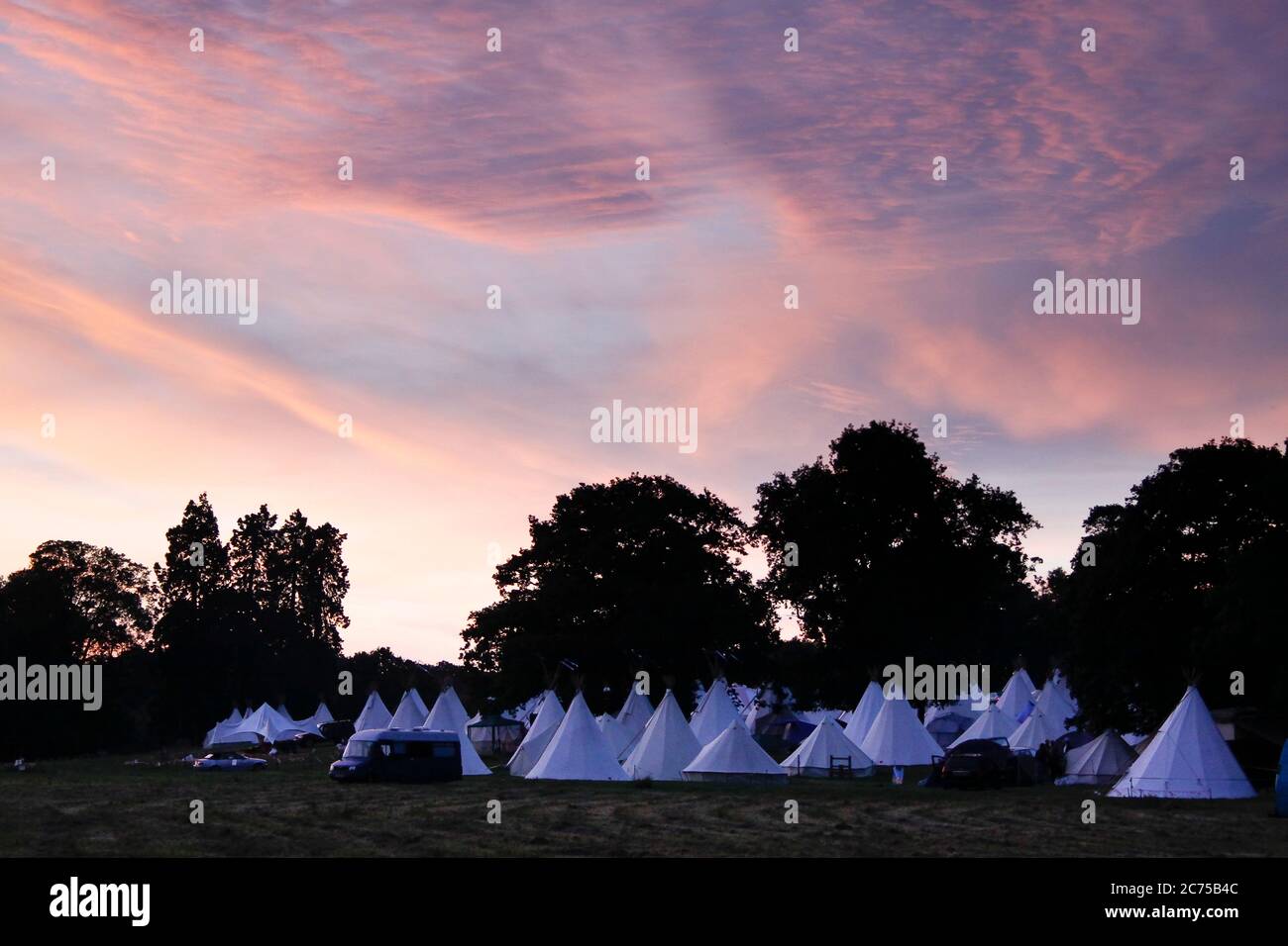 Tipi glamping field with at a festival campsite at sunset, Norfolk ...