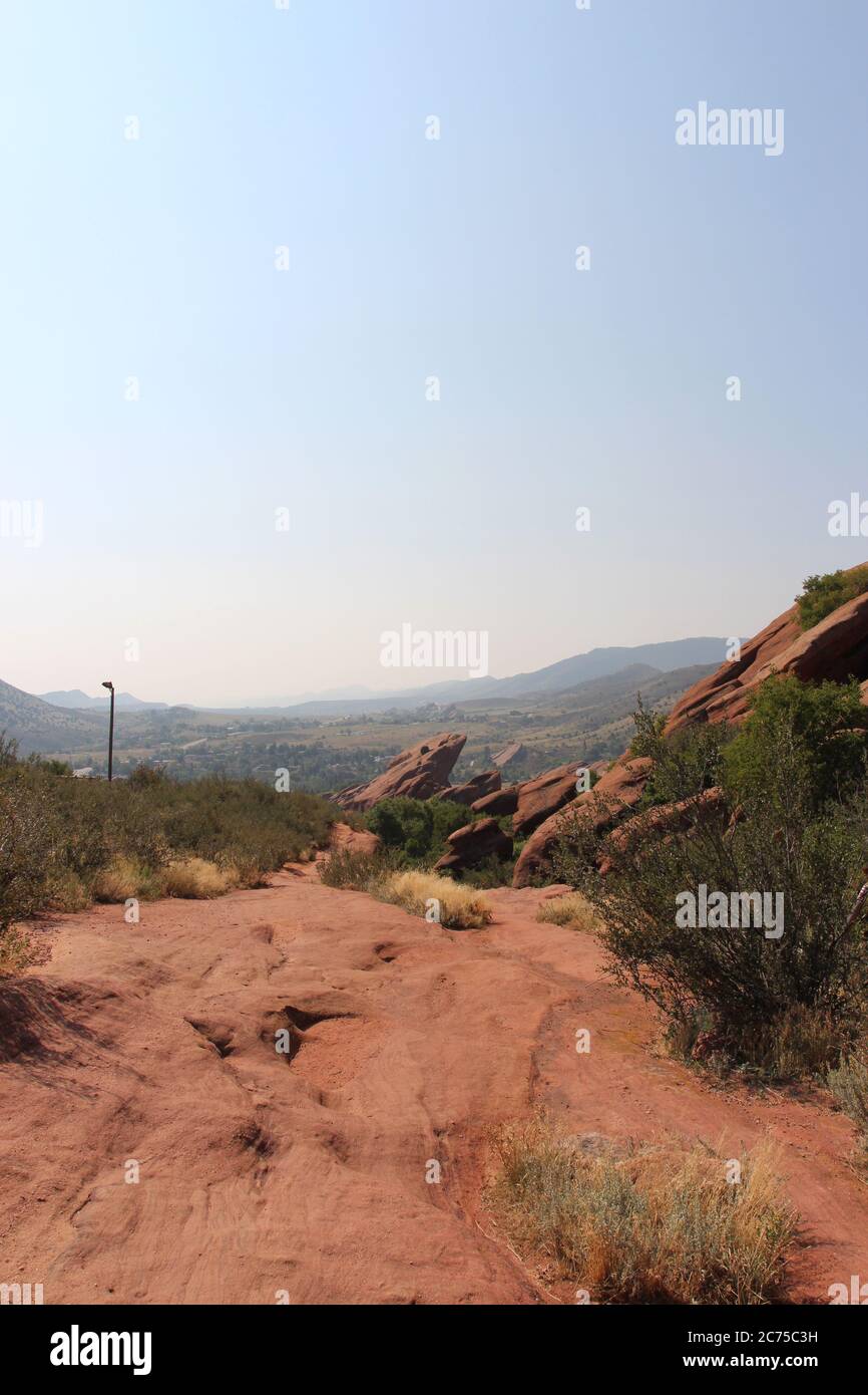 Trading Post Trail lined with large rock formations and vegetation with ...