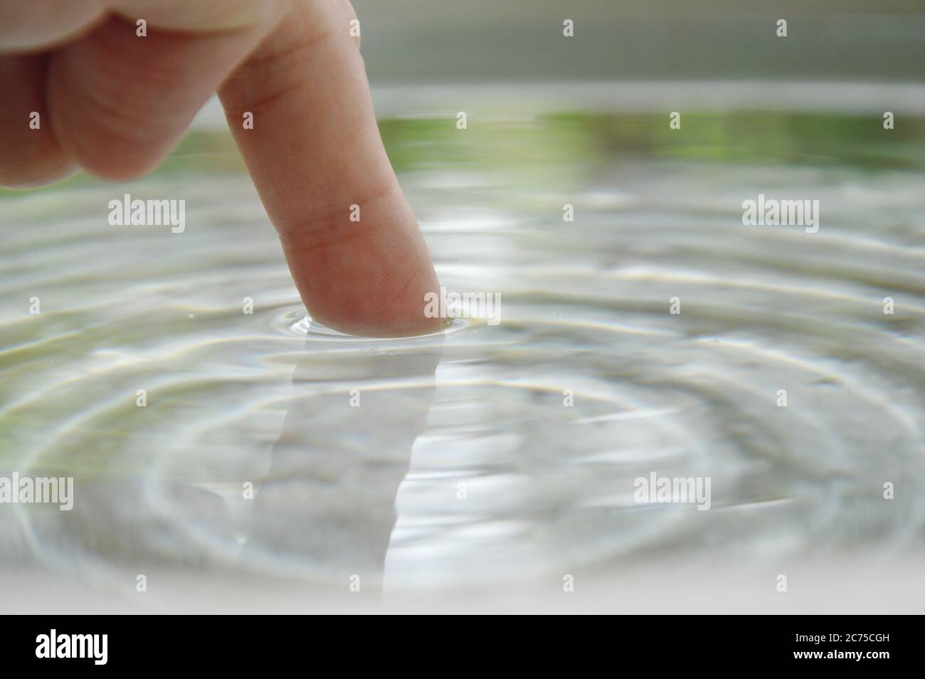 human finger touching on water surface Stock Photo - Alamy