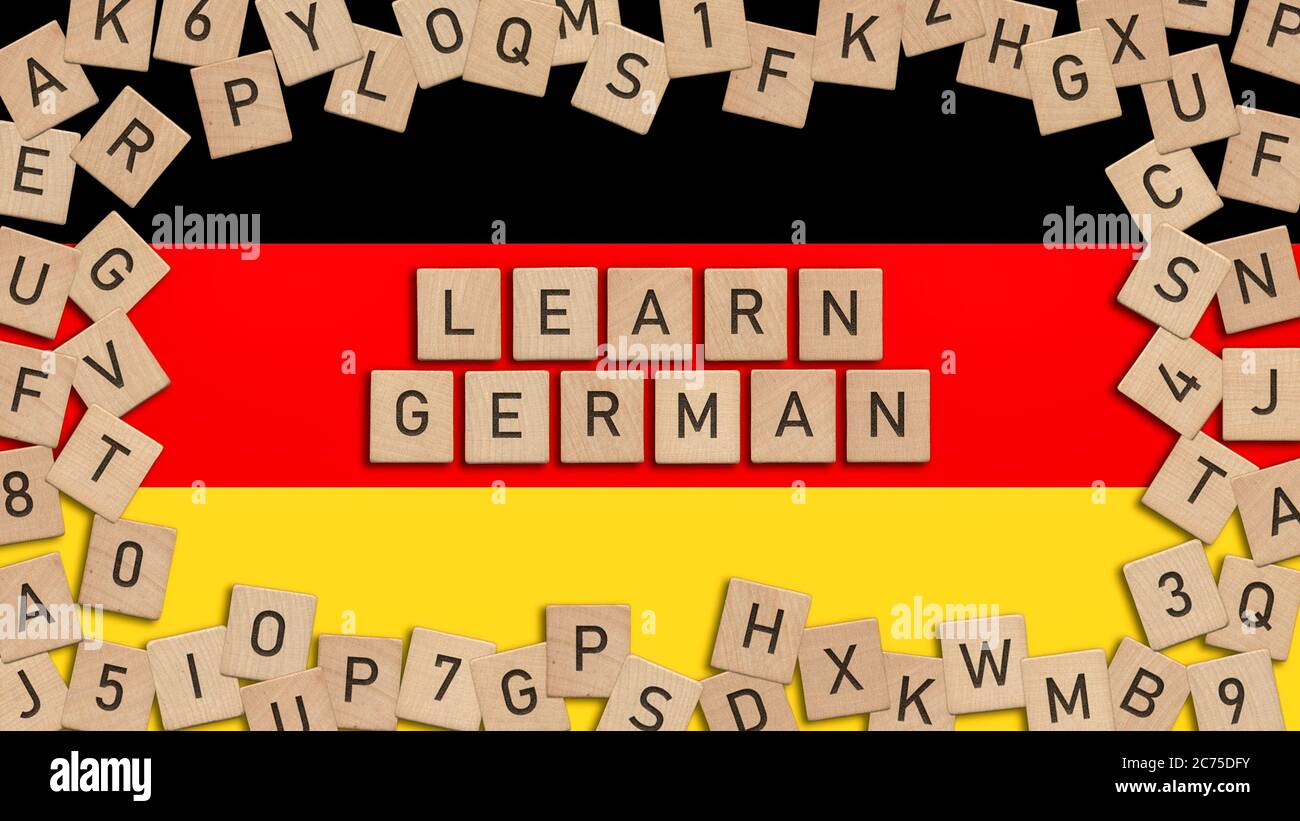 Learn German word written with wooden tiles over German flag. This ...