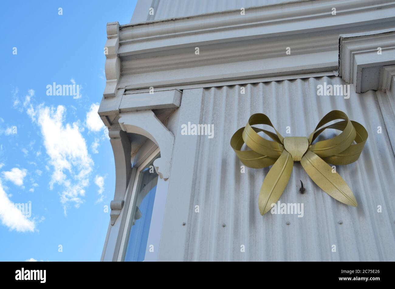 A big golden metal ribbon hanging outside the wall Stock Photo - Alamy