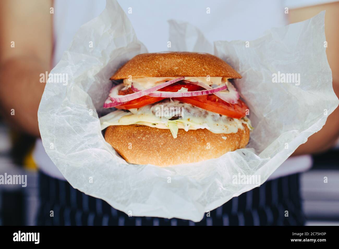 Cook preparing burger adding the sauce on the cream cheese. Three ...