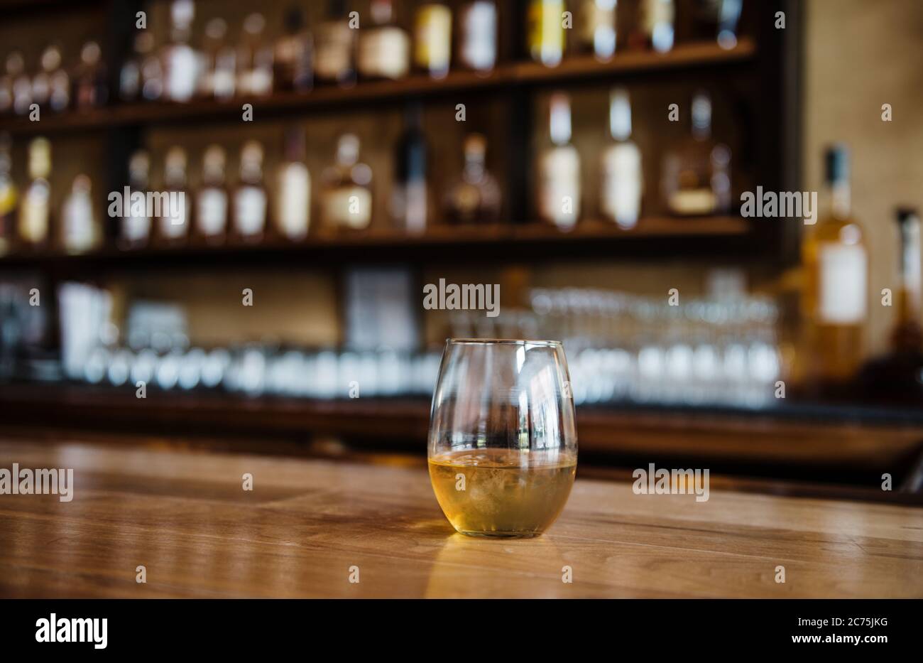 Glass of whiskey on the rocks in a bar setting Stock Photo - Alamy