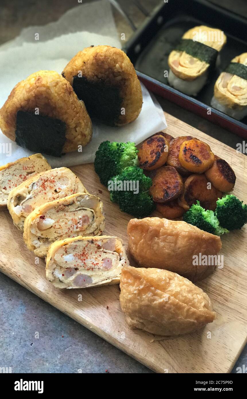 Homemade sushi and assorted snack like prawn tamago, pan fried tomatoes ...