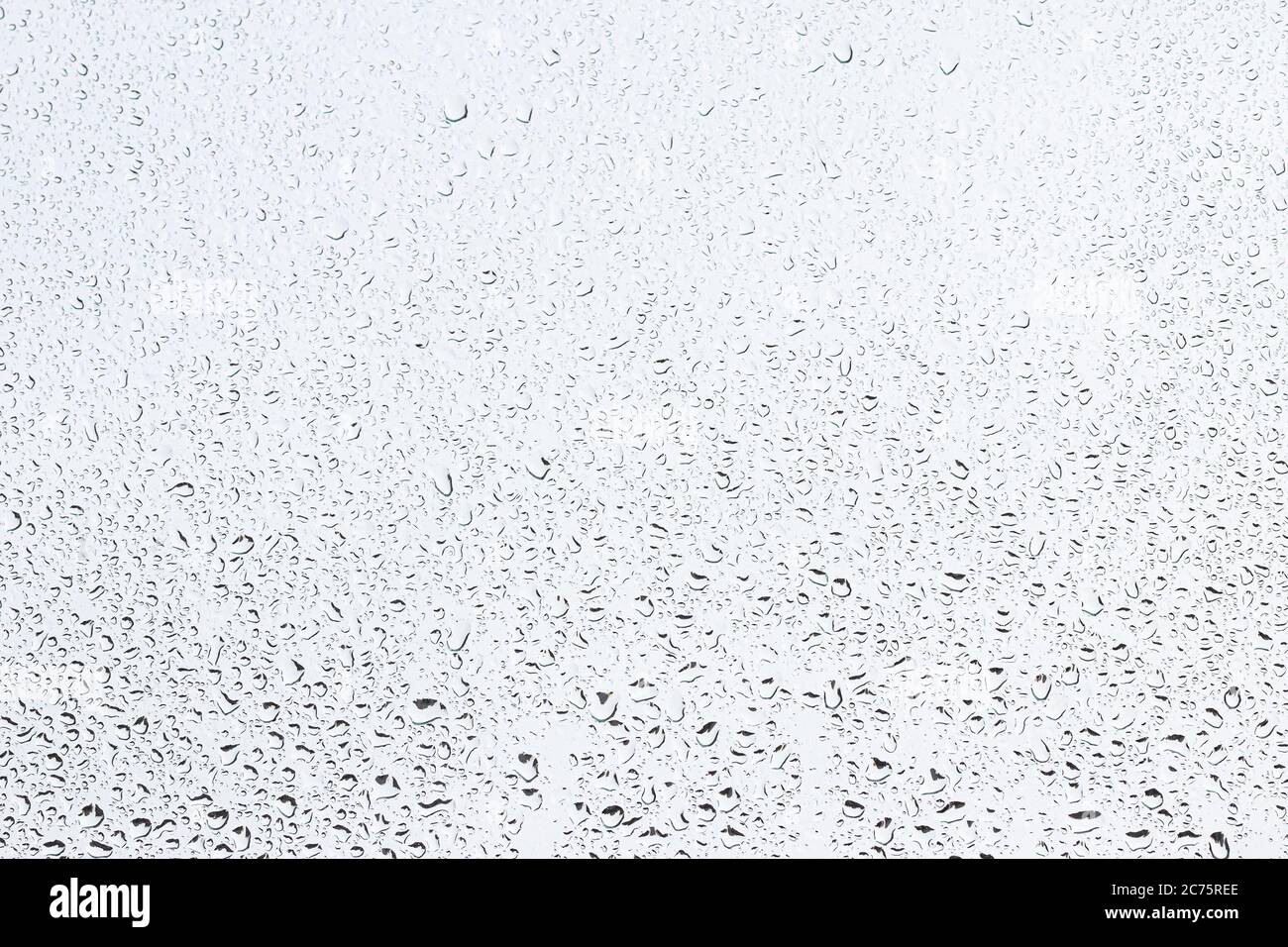 Rain drops on window glasses surface with gray sky background . Natural ...