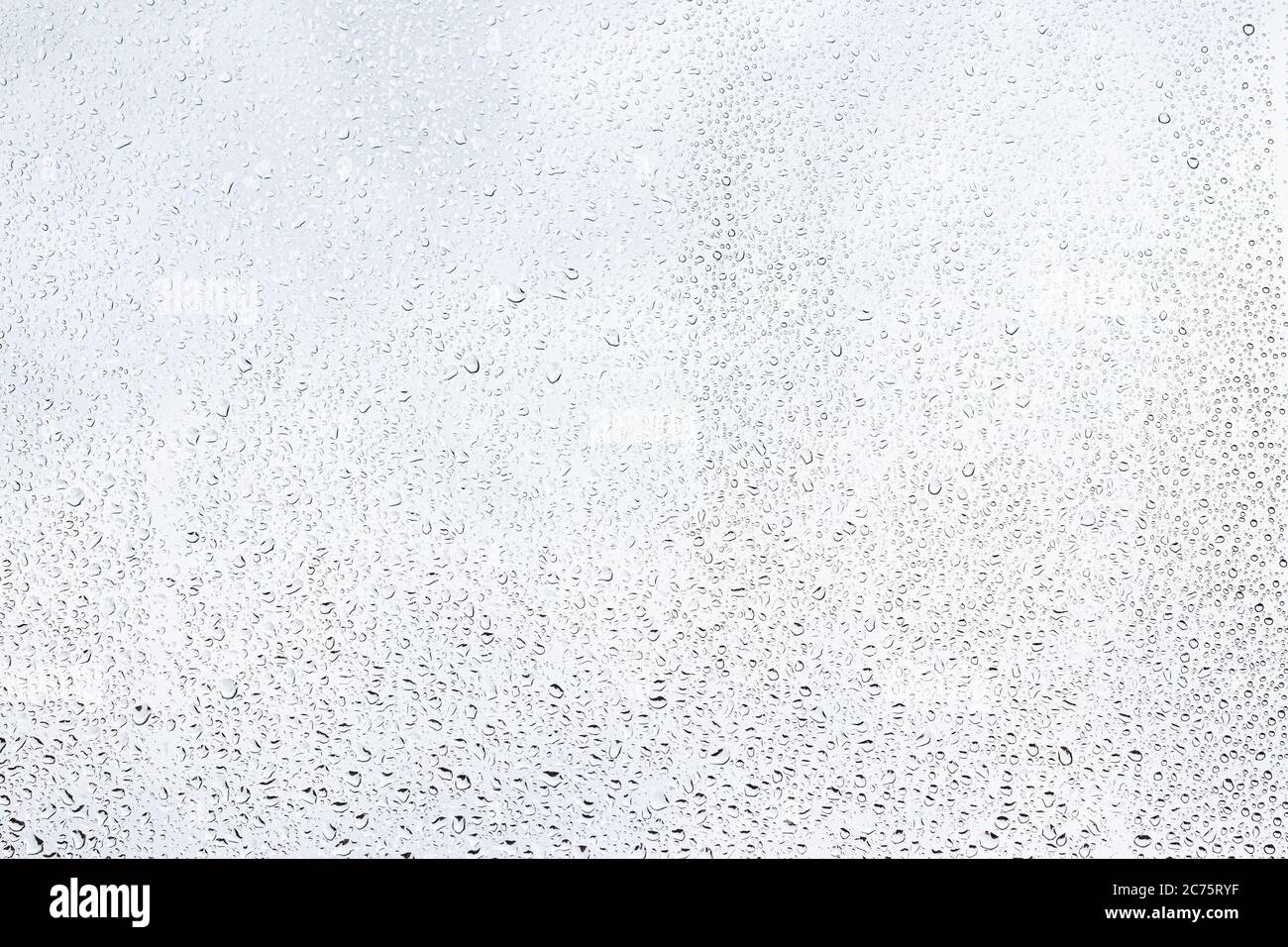 Rain drops on window glasses surface with gray sky background . Natural ...