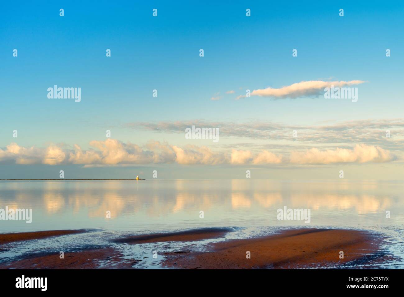 Golden early morning clouds reflect in the still waters of Summerside ...