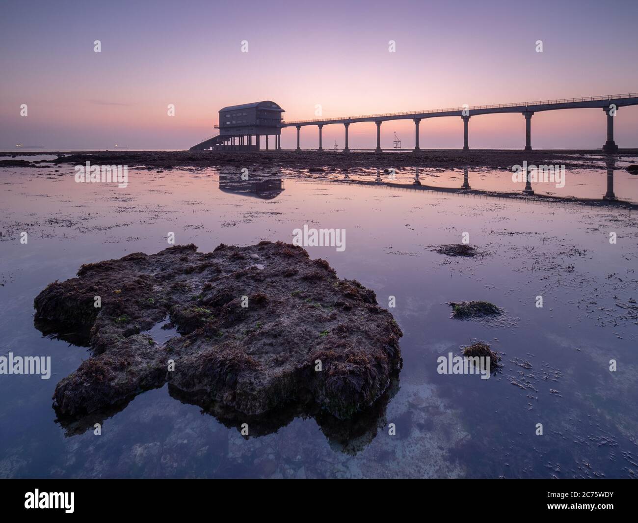 Bembridge Lifeboat Station is silhouetted against the purple tones of a ...