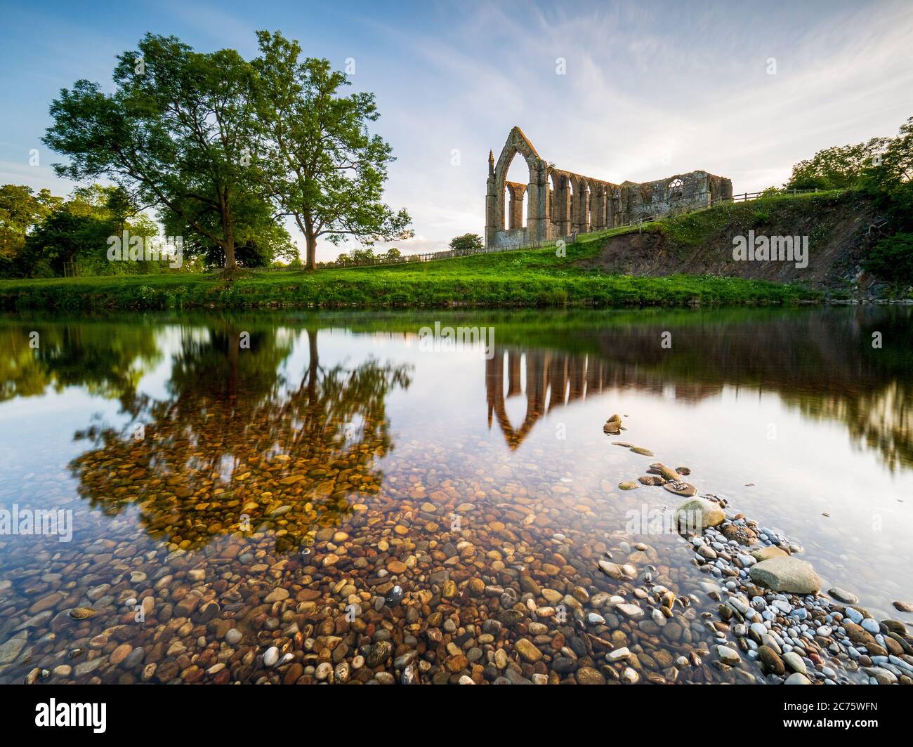 The ruins of Bolton Abbey are reflected in the River Wharfe on a calm ...