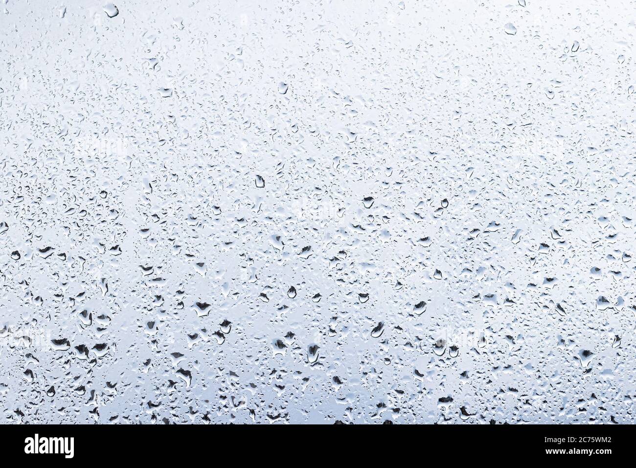 Rain drops on window glasses surface with cloudy sky background ...