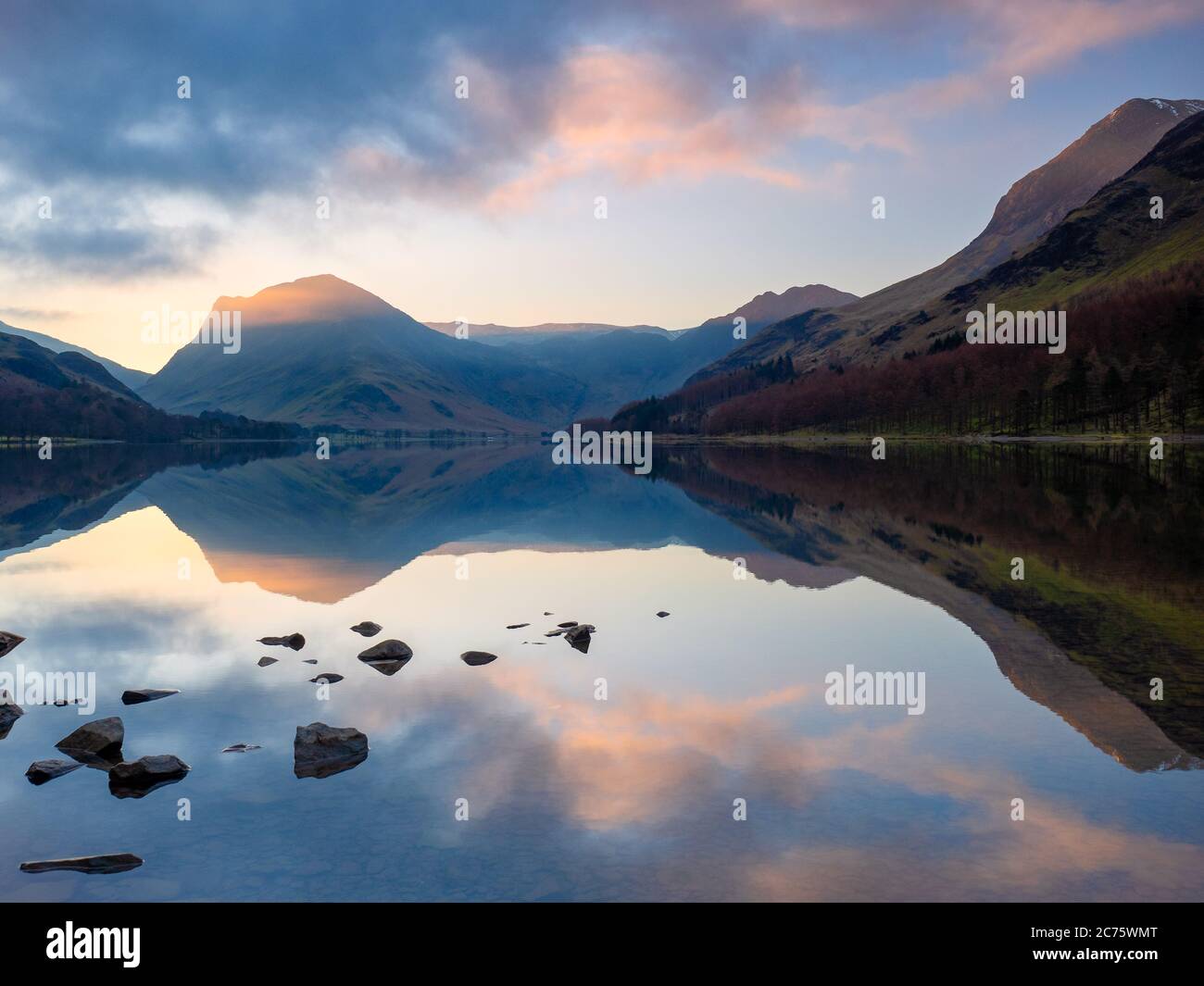 The mountains of the Northern Lake District are reflected in the still ...