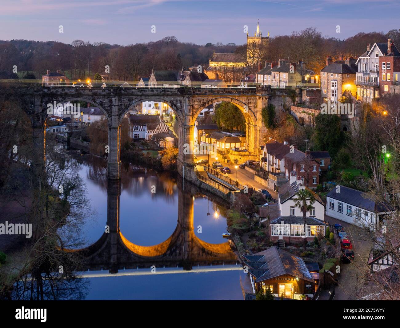 The arches of the Nidd Viaduct in Knaresborough glow orange against the ...