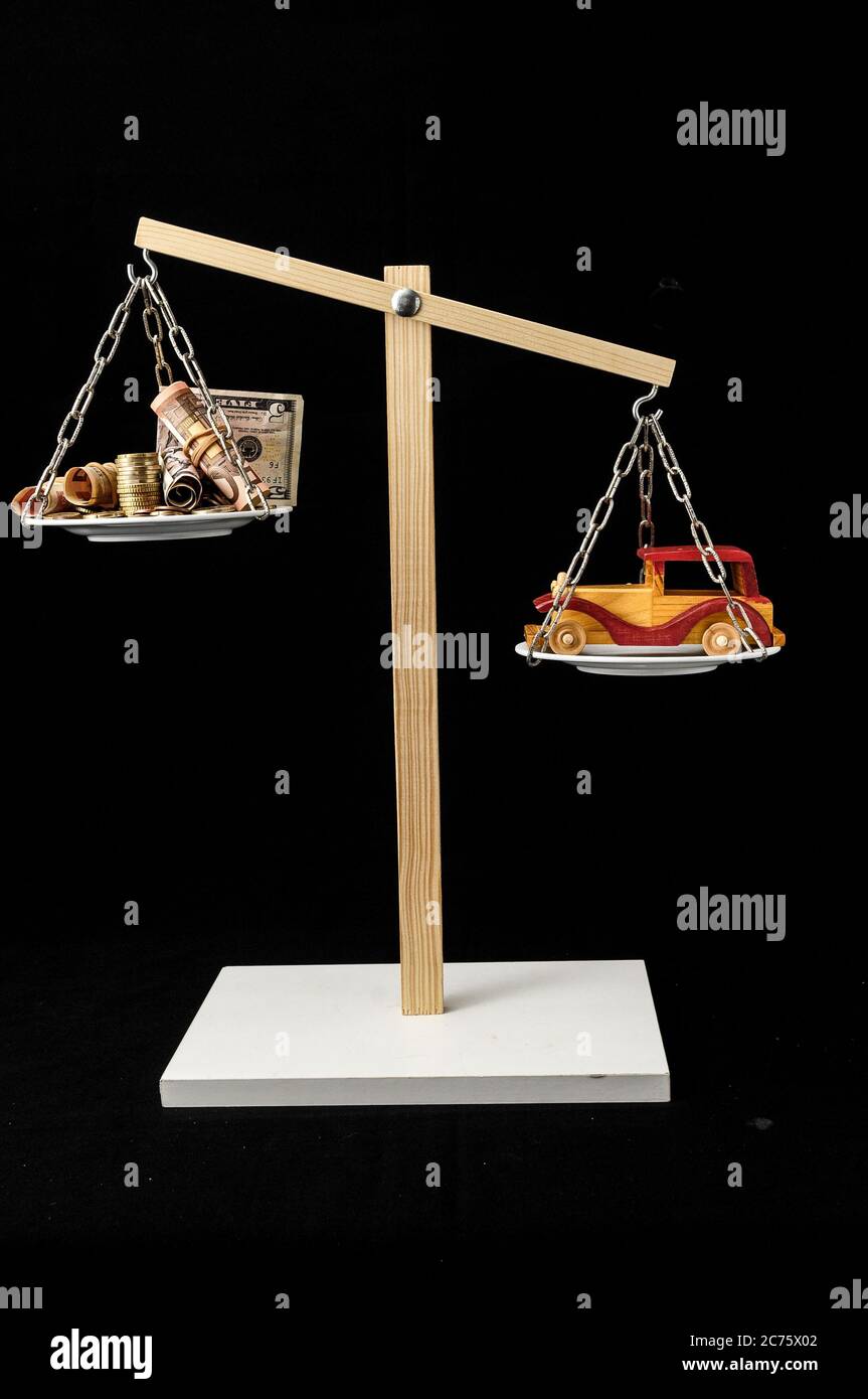 Money and Toy Wooden Car on a Two Pan Balance Stock Photo - Alamy