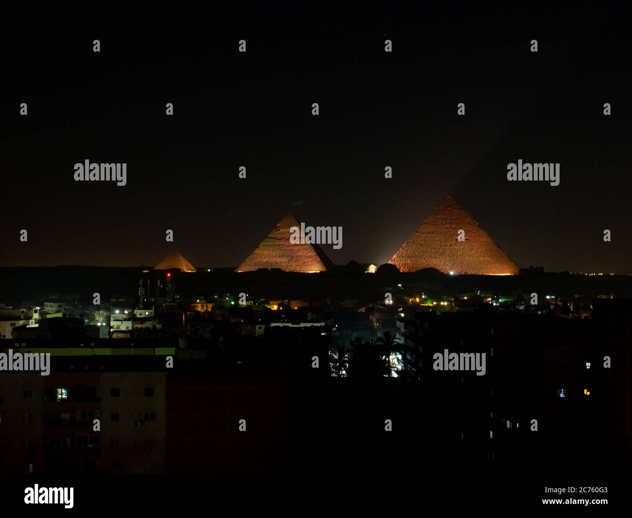 pyramids with skyline of giza at night with illustration lightshow ...