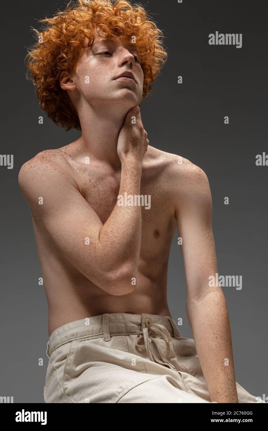 Art view. Fashion portrait of beautiful redhead man isolated on grey ...