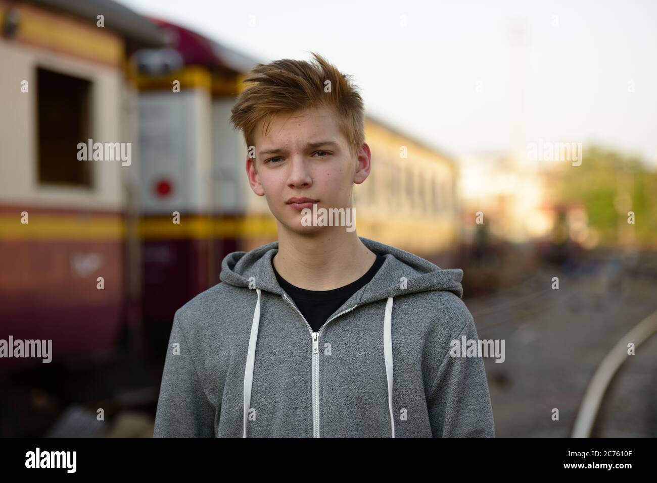 Young handsome teenage boy at the railway train station Stock Photo - Alamy
