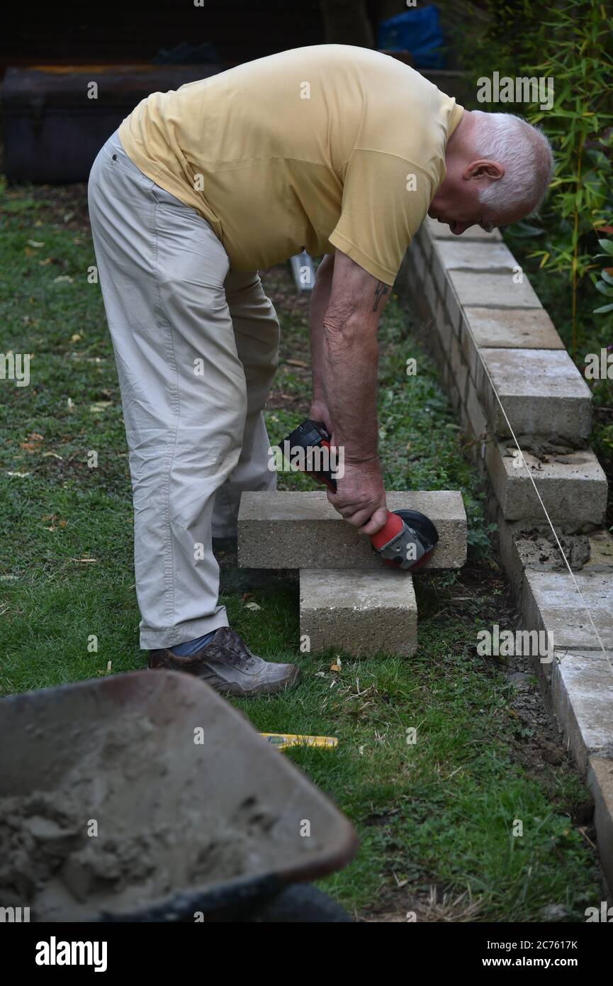 Older caucasian man performing brick laying Stock Photo - Alamy
