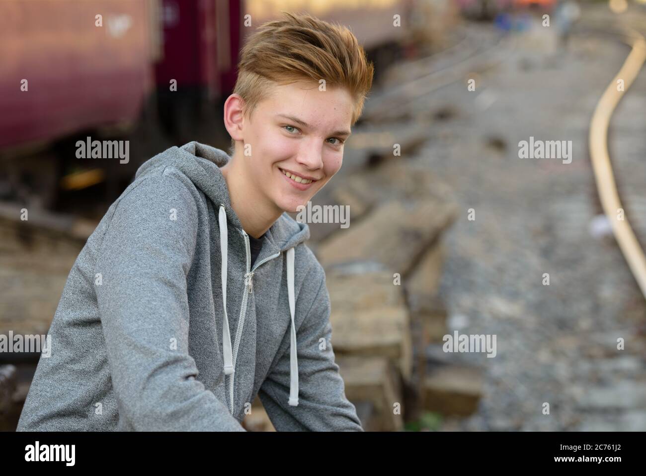 Young handsome teenage boy at the railway train station Stock Photo - Alamy