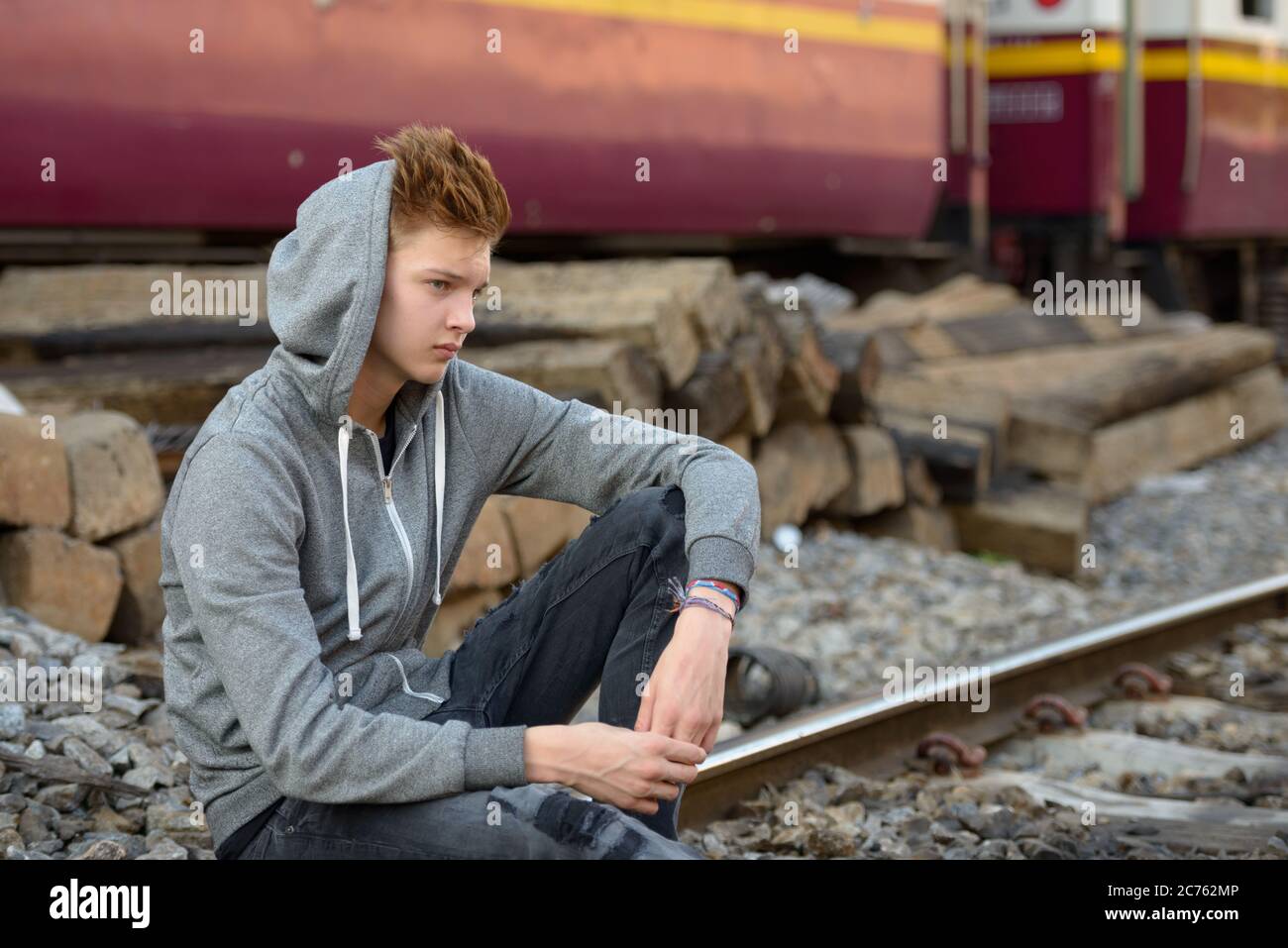 Young handsome teenage boy at the railway train station Stock Photo - Alamy