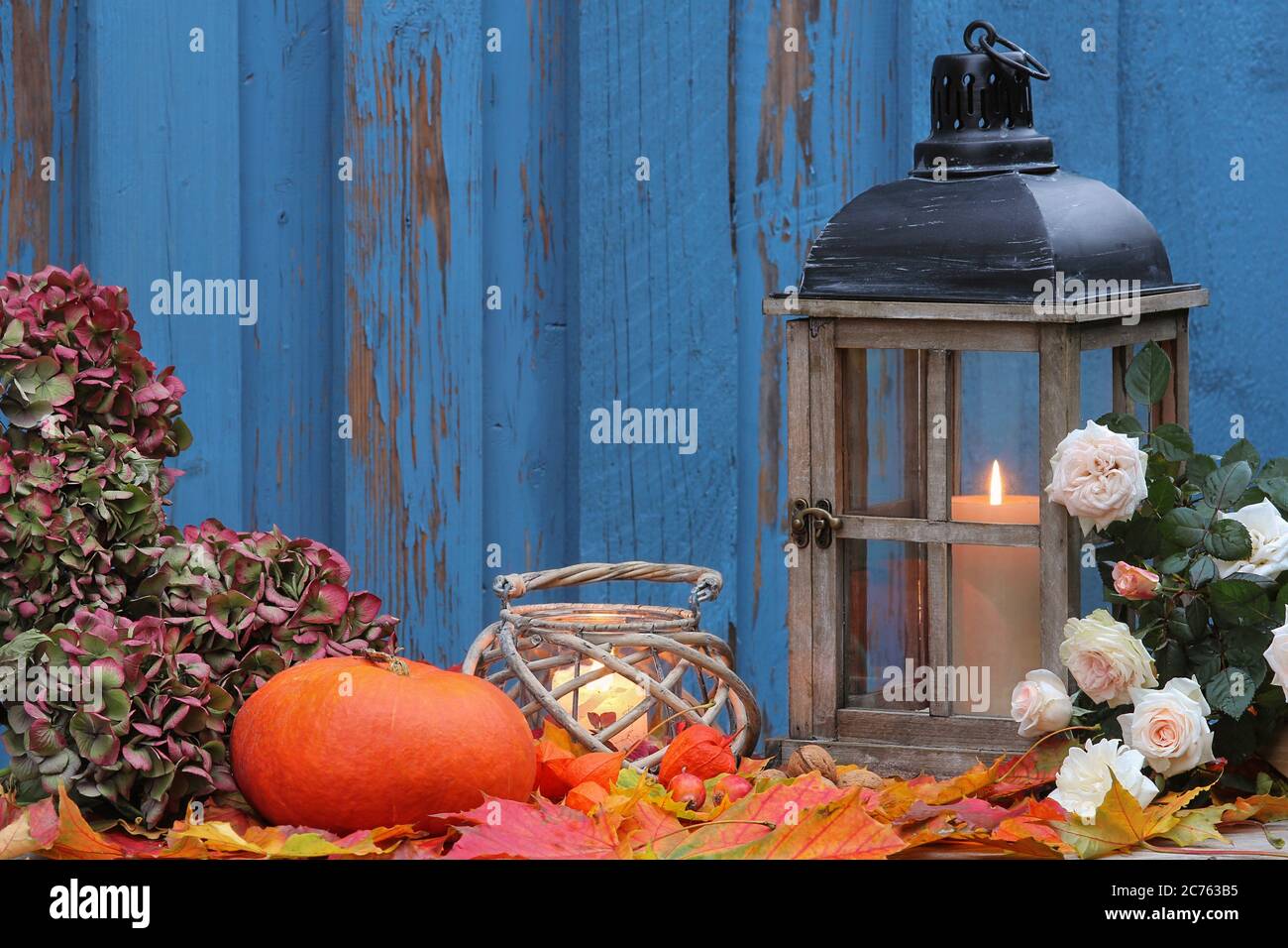 Pumpkin, storm lamp and lantern with white roses Stock Photo - Alamy
