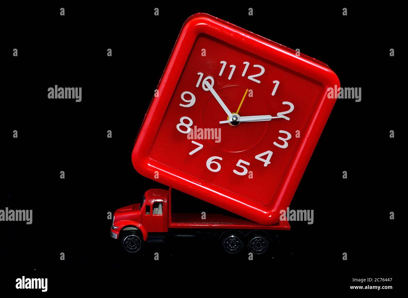Time Transportation Concept Clock Watch on a Red Toy Truck over Black ...