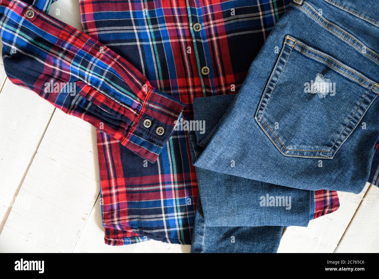 Clothes concept. Checkered shirt and jeans on wooden background. Top ...