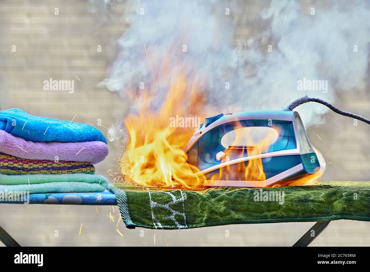 An electric iron for clothes caught fire on an ironing board indoors ...