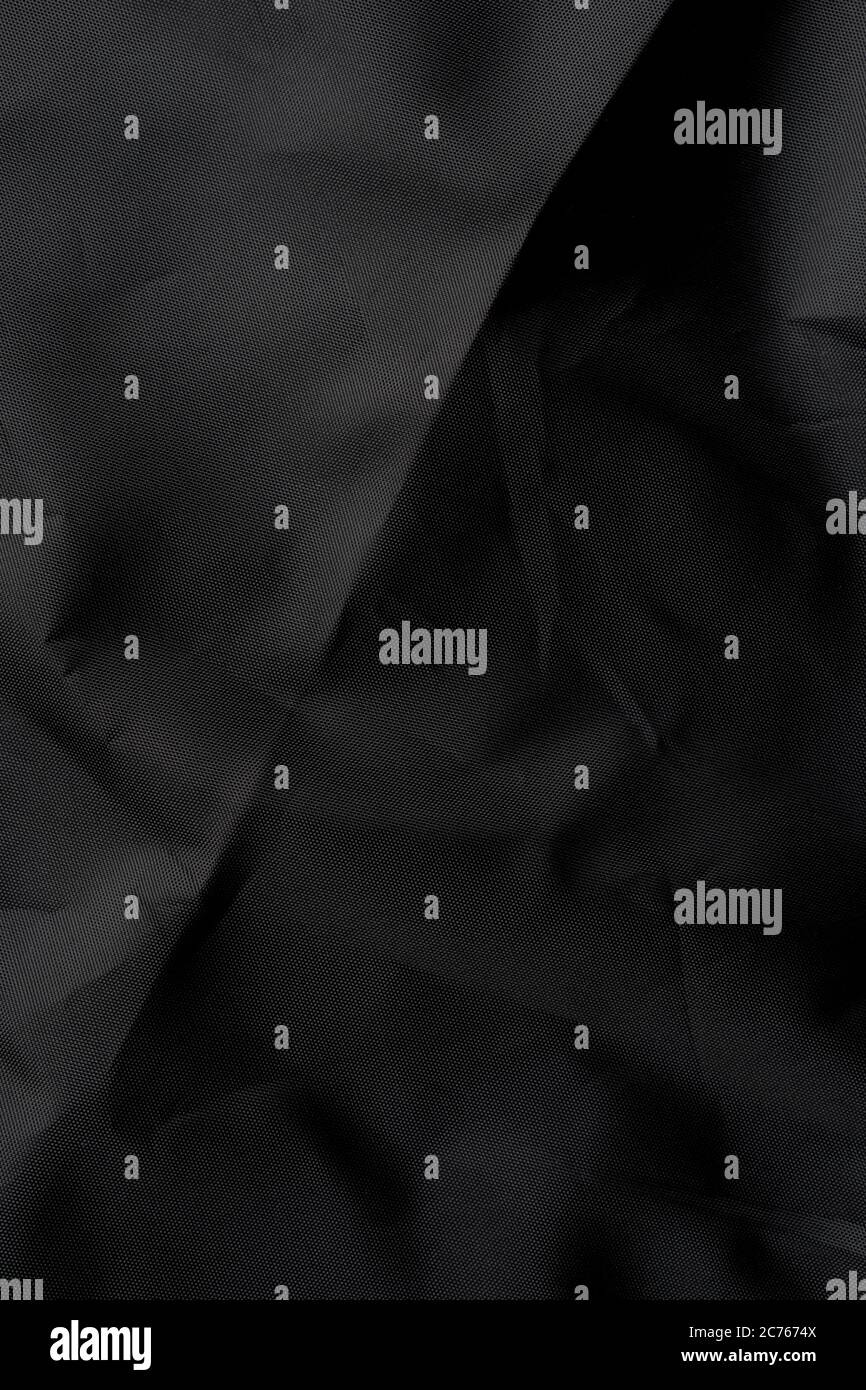 Abstract black synthetic material with wrinkles and wrinkled folds. Old ...